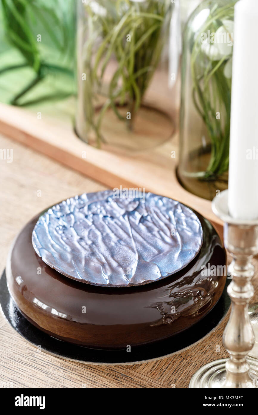 Luxury round chocolate dessert, with a blue disk on Black glaze. Mousse ...