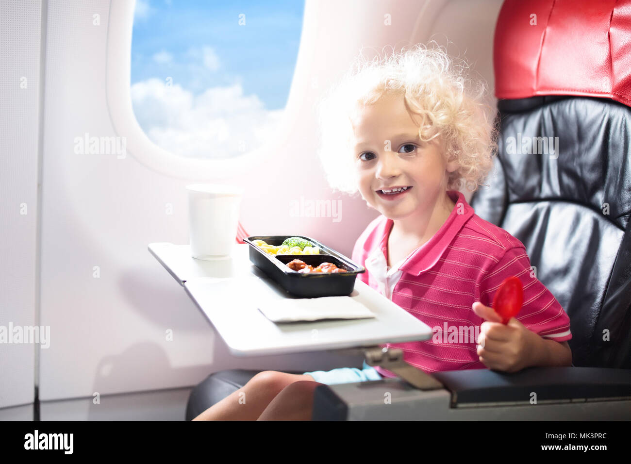 Child in airplane window seat. Kids flight meal. Children fly. Special ...