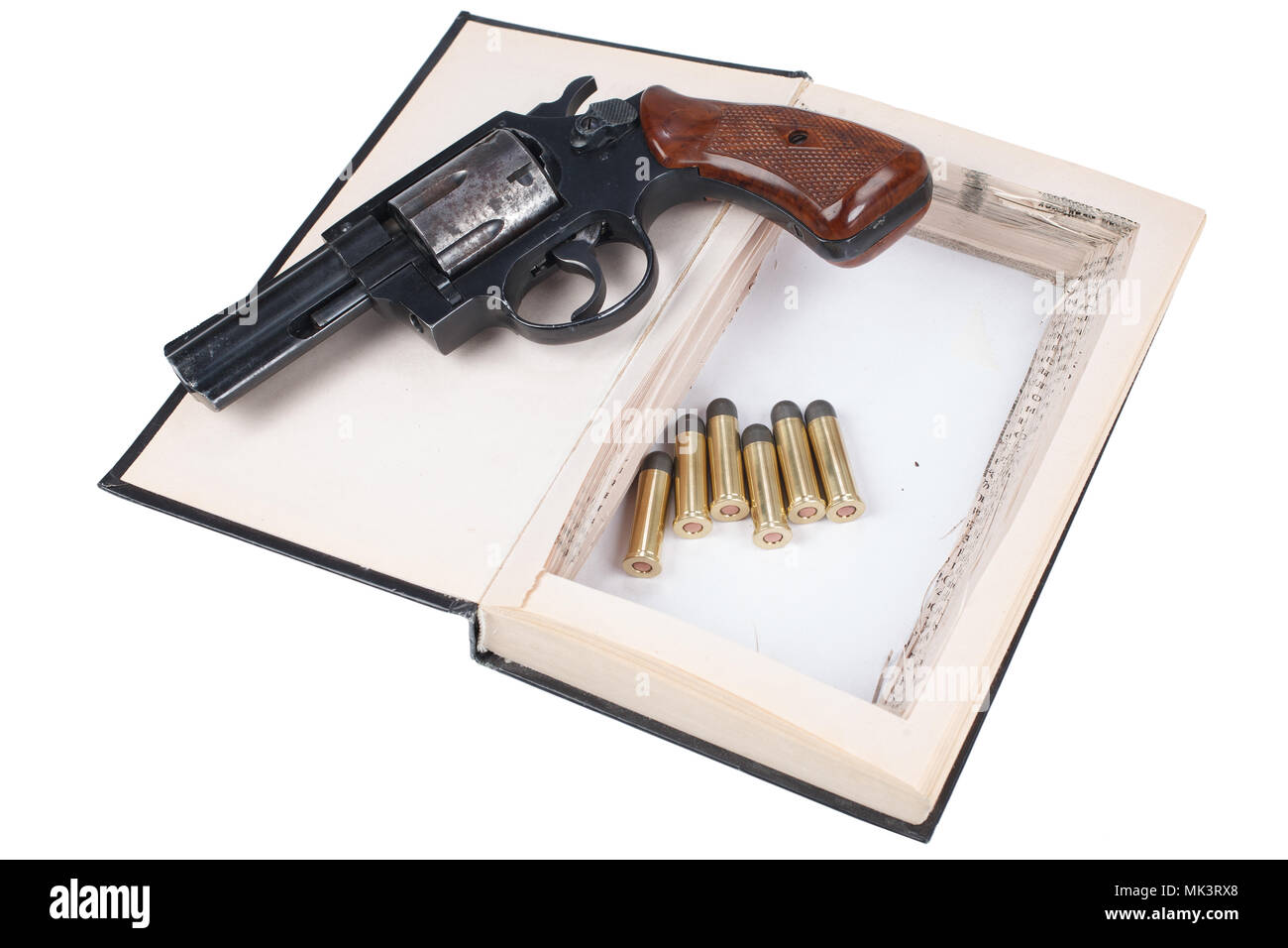 Revolver gun with cartridges hidden in a book isolated on white ...