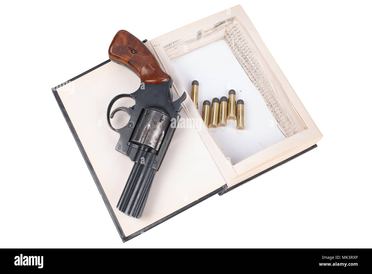 Revolver gun with cartridges hidden in a book isolated on white ...