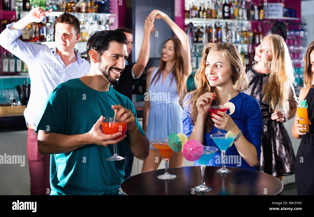 Cheerful positive man with woman are drinking cocktails on corporate ...