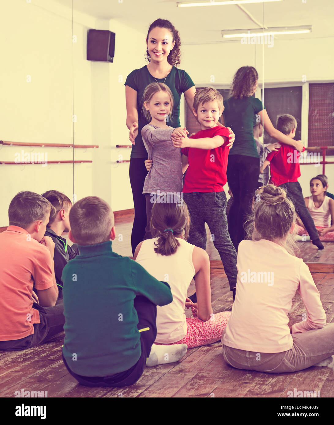 Group of kids with female teacher dancing pair dance in dance class ...