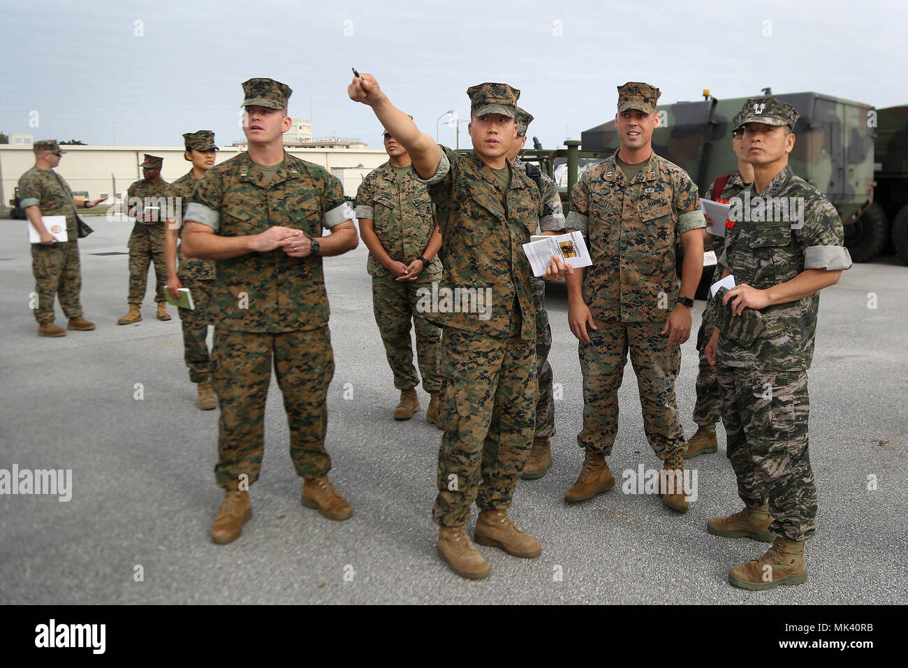 U.S. Marine 2nd Lt. Gene Jung, center, translates for the official ...