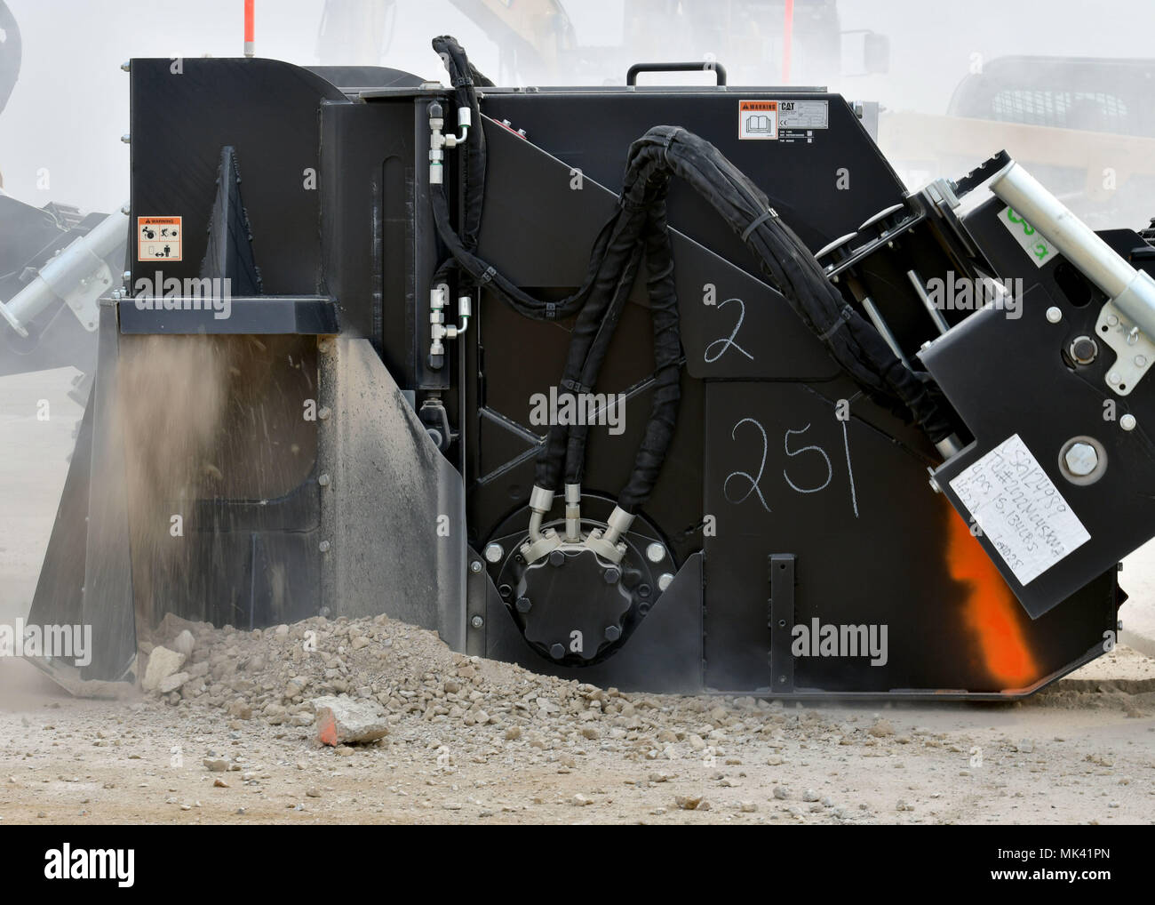 A compact track loader saw cutter, cuts a square around damaged ...