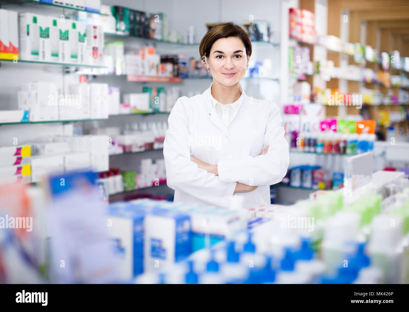 positive italian female pharmacist demonstrating assortment of pharmacy ...