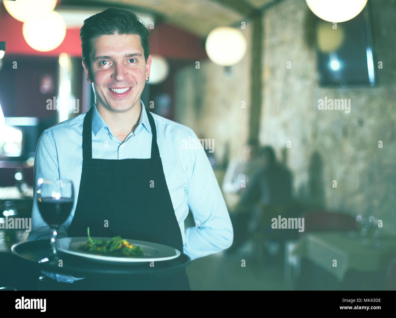 Handsome adult waiter with serving tray welcoming to restaurant Stock ...