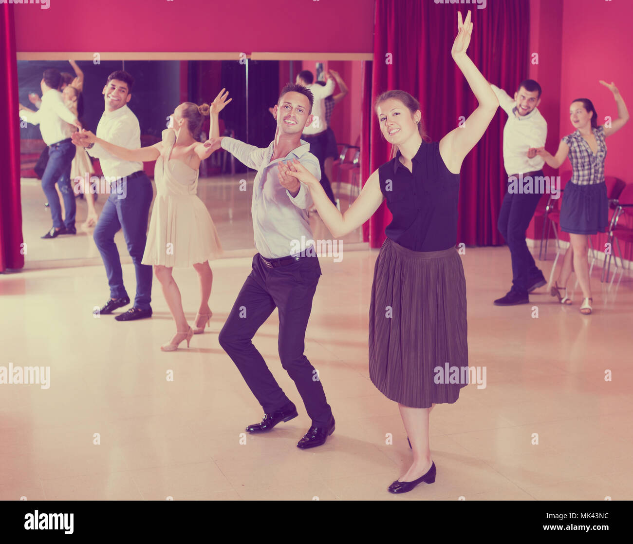 Young dancing couples enjoying latin dances in modern studio Stock ...