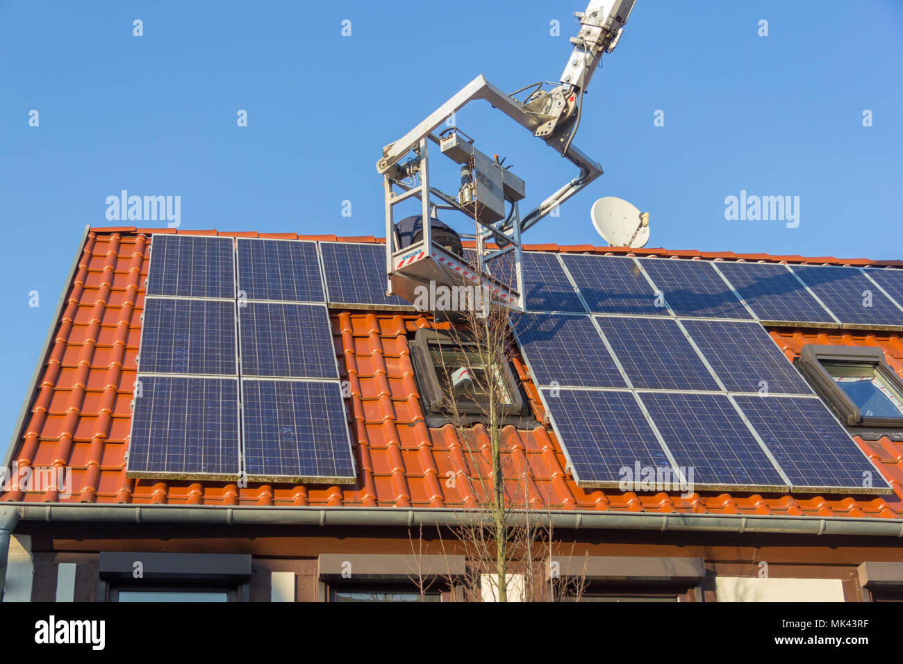 A german worker is mounting a photovoltaic system on a roof Stock Photo ...