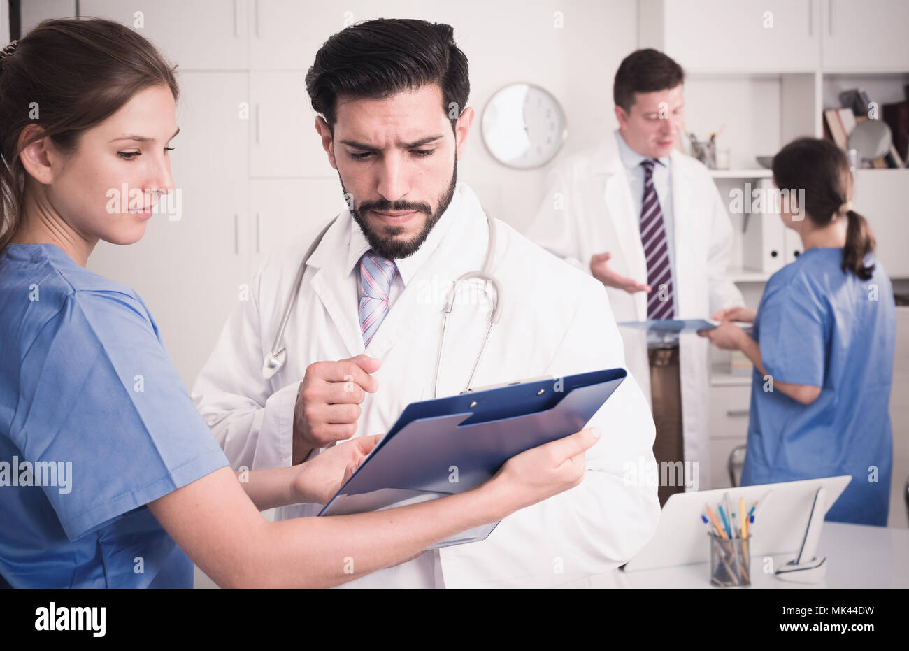 Doctor giving his younger female colleague piece of advice concerning ...