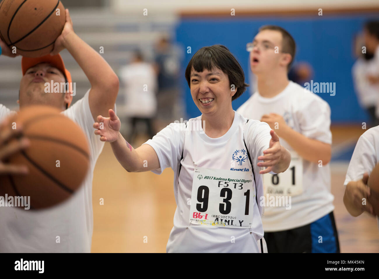Aimi, Kadena Special Olympic athlete, holds her arms out to catch a ...