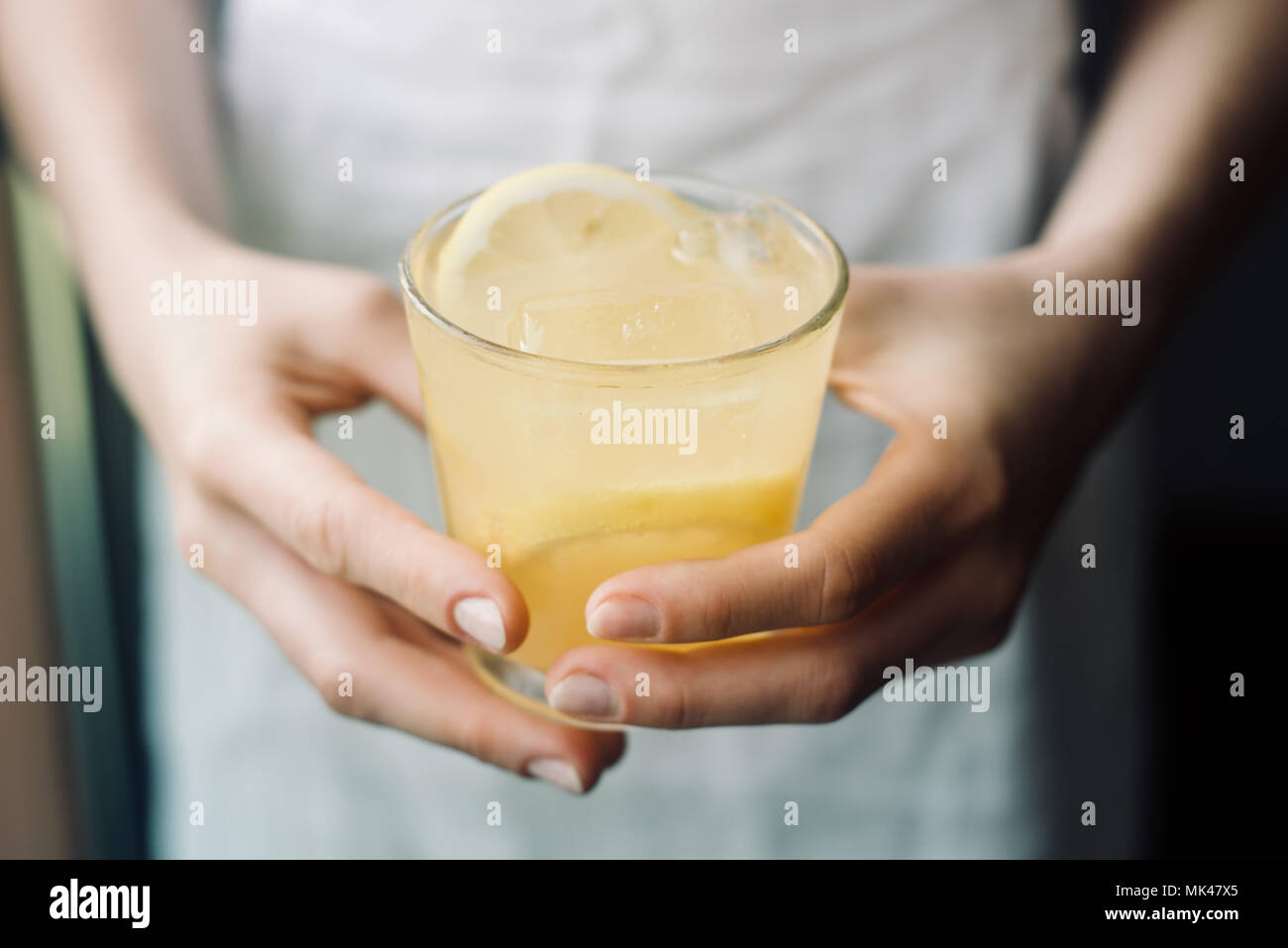 a woman drinking lemonade at home, woman keeping in hands a glass of ...