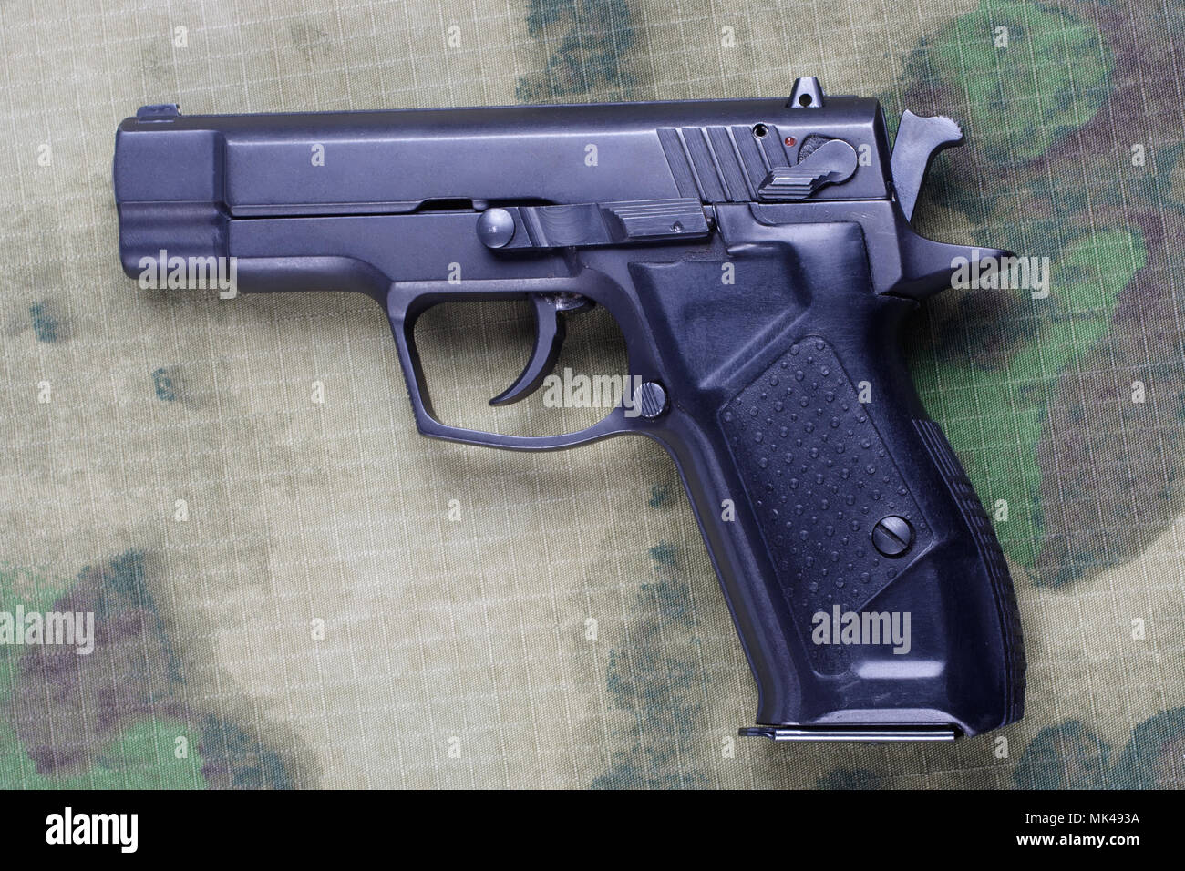 modern handgun on camouflage background Stock Photo - Alamy