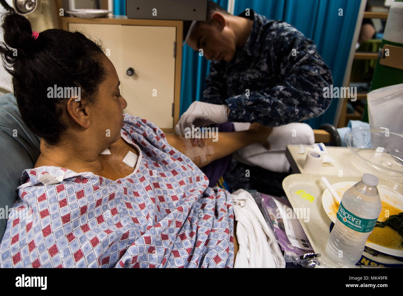U.S. Navy Hospitalman Benjamin Cady, removes an IV from Jessica Maria ...