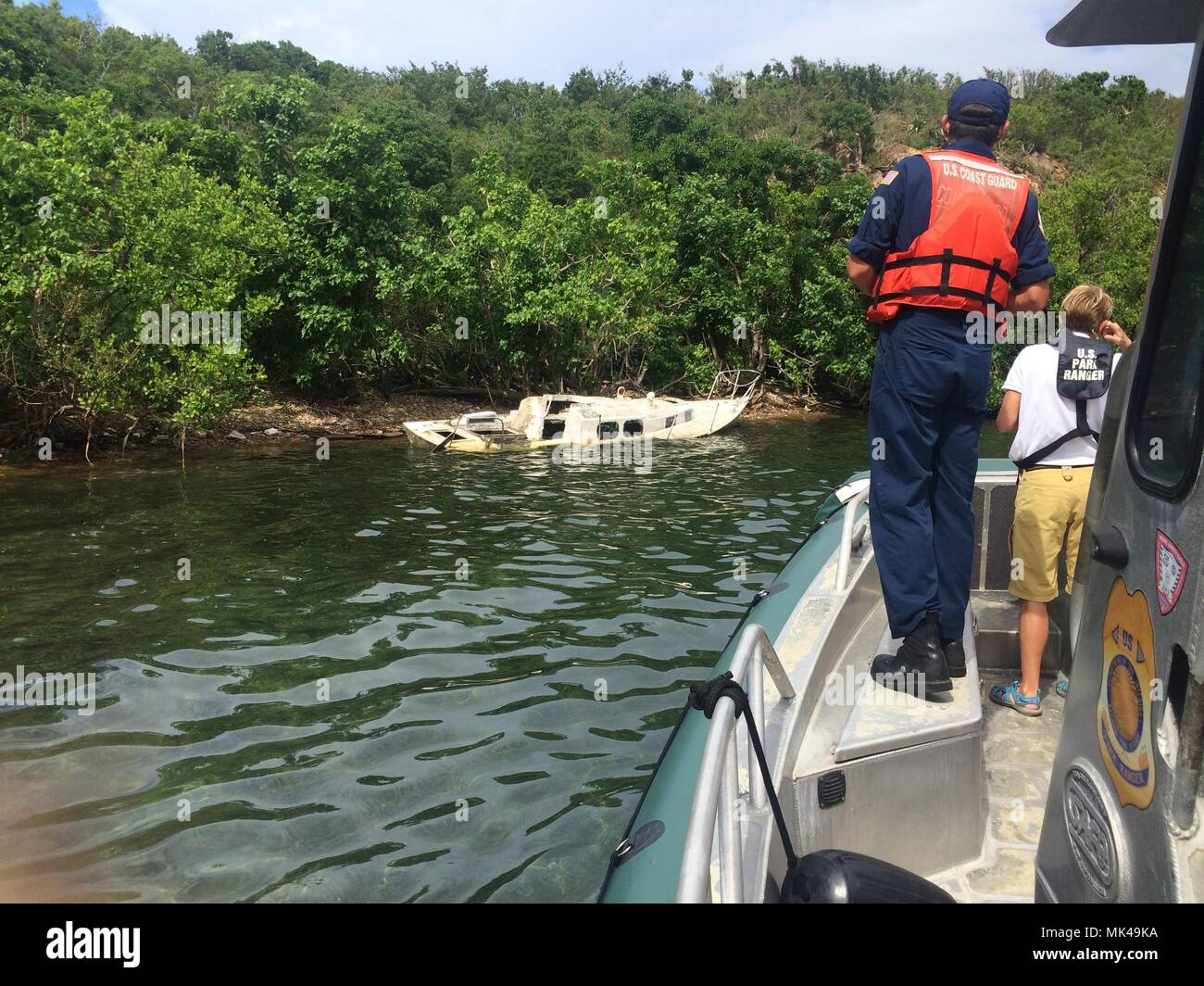 Coast Guard crewmember works with a National Park Service member to ...