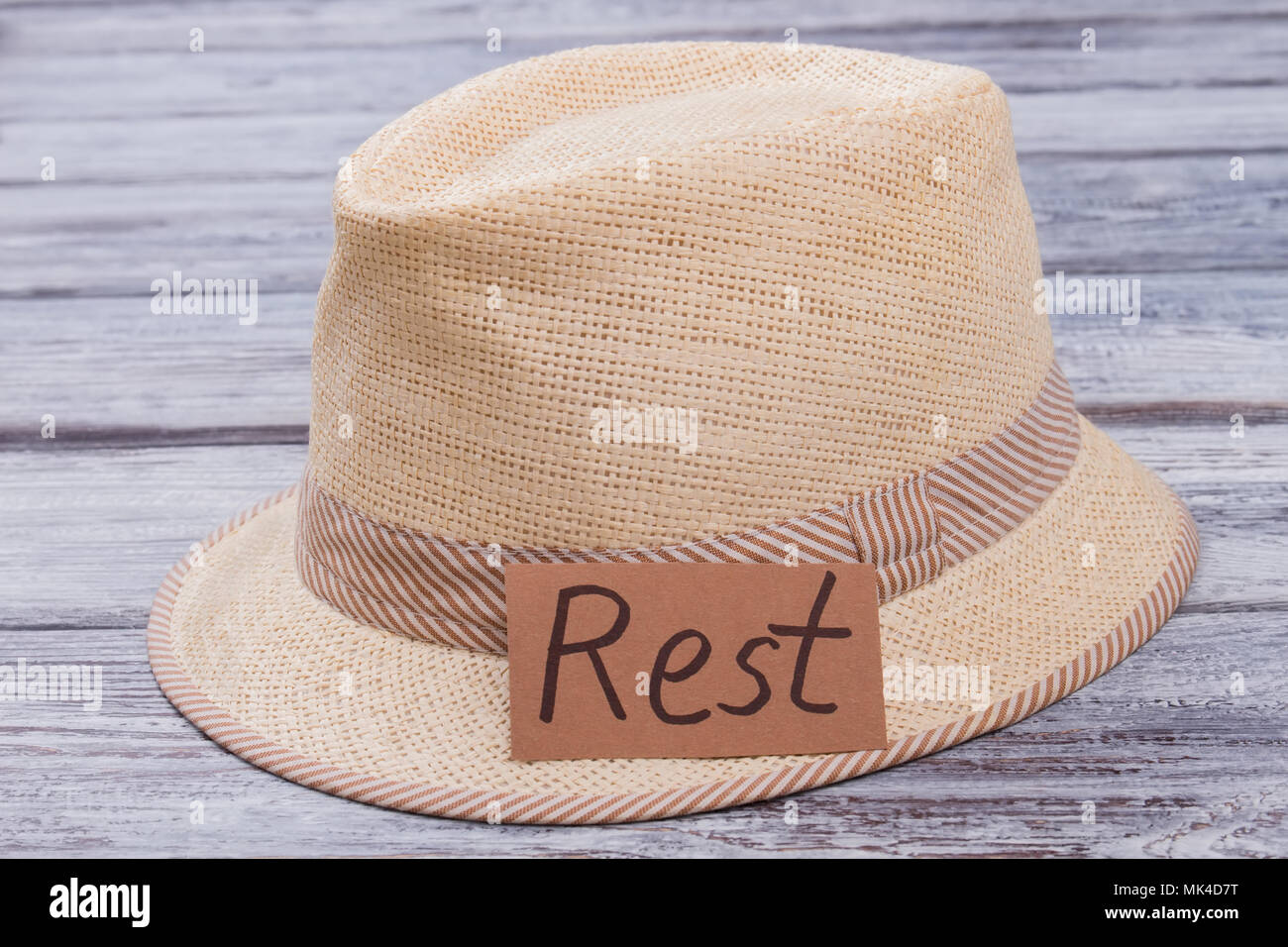 Beige straw hat for rest on the beach. Dark wooden desk surface ...
