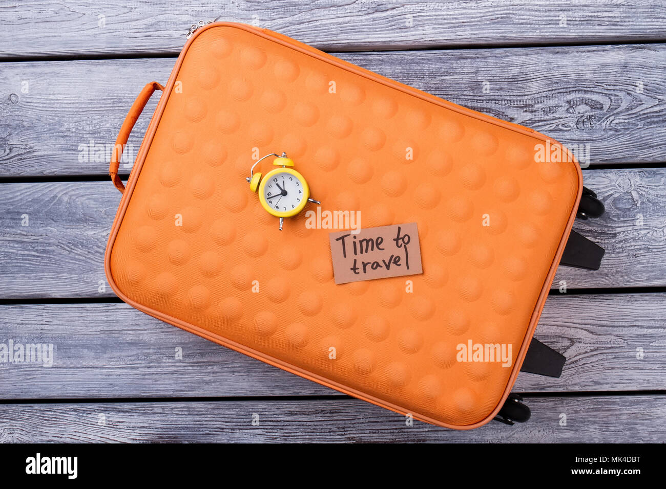 Time to travel flat lay. Orange suitcase and alarm clock Stock Photo ...