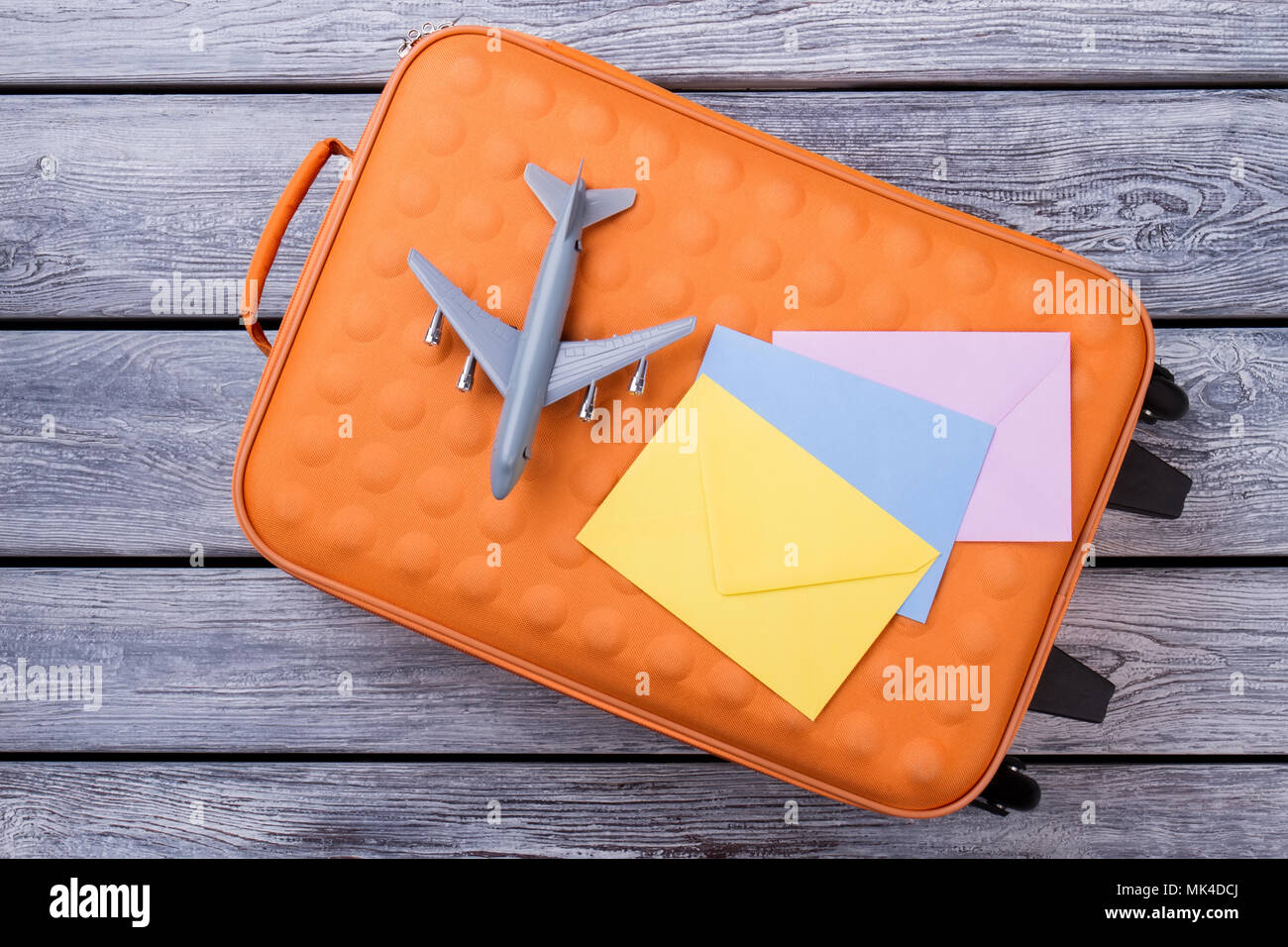 Travel stuff, top view. Suitcase, toy airplane and colourful post mails ...