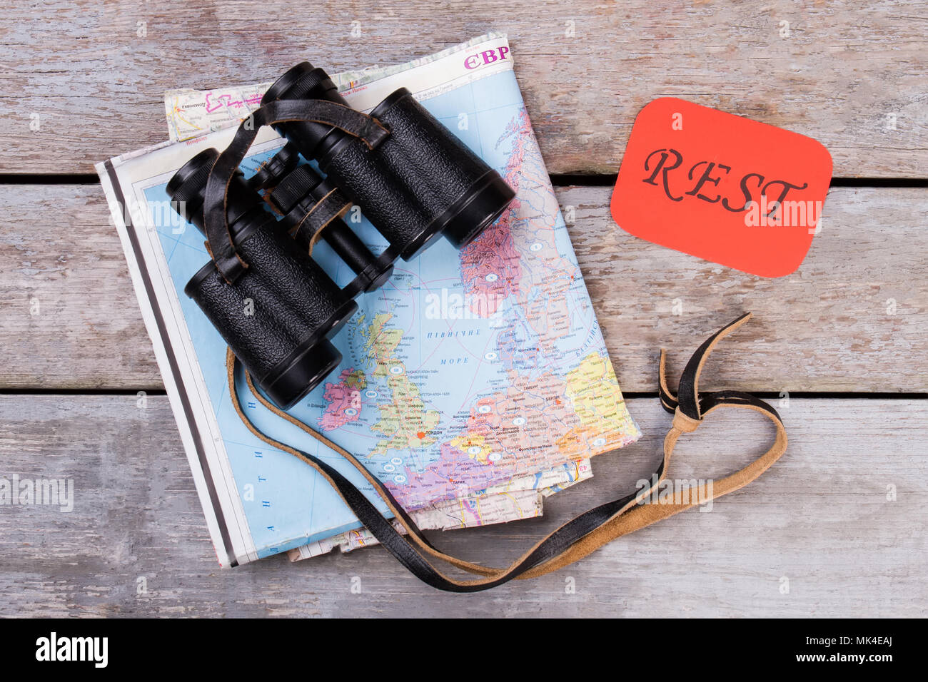 Binoculars and map flat lay. Rest concept, red label. Wooden table surface background Stock ...