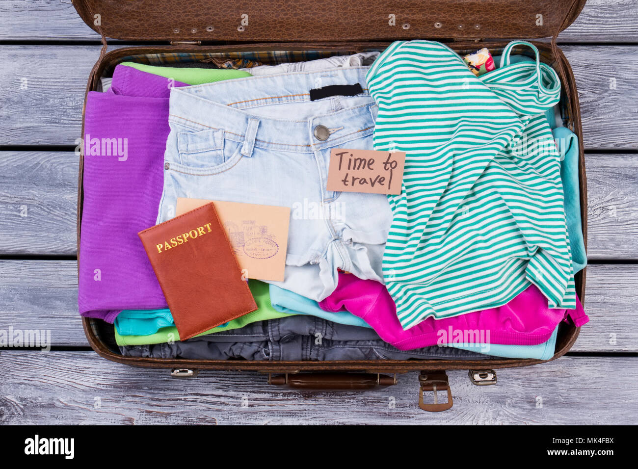 Suitcase packed with folded clothes and accessories. Top view, flat lay ...