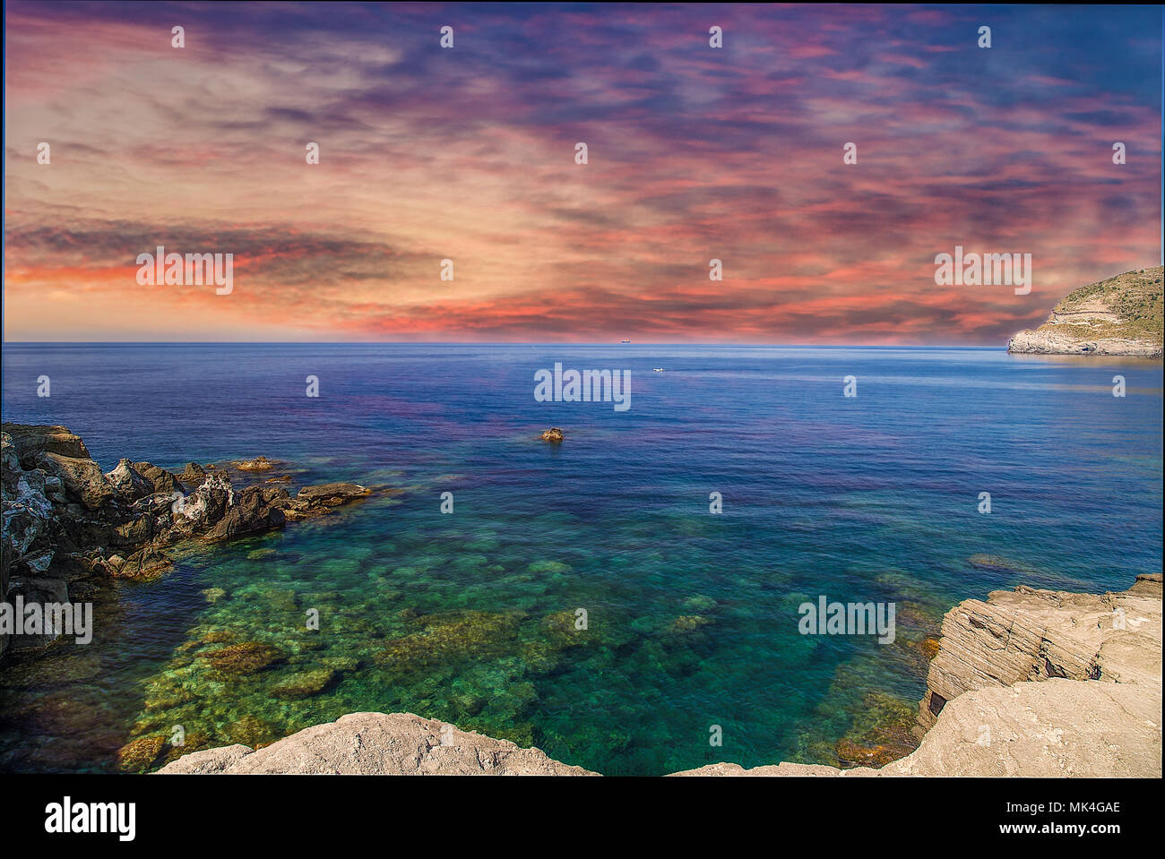 purple sunset on Italian rocky coast Stock Photo - Alamy