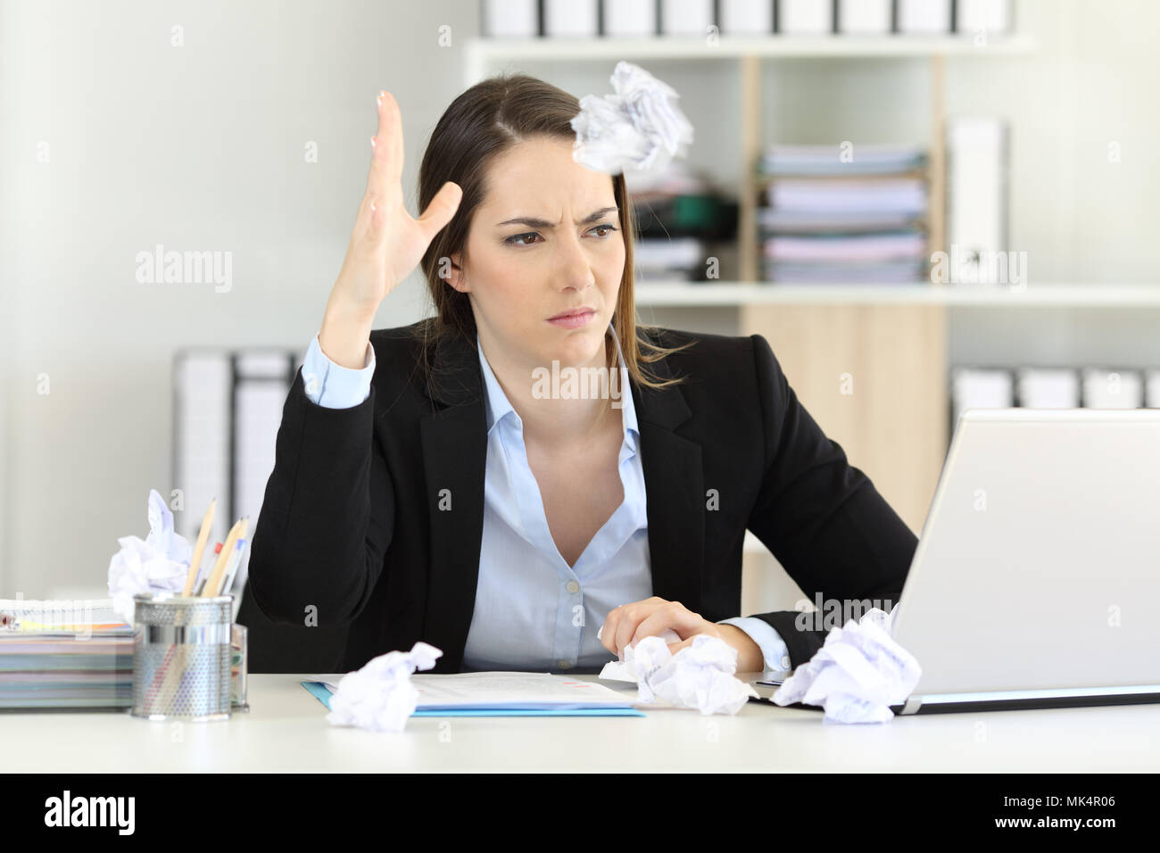 Frustrated executive without inspiration throwing a paper ball at ...