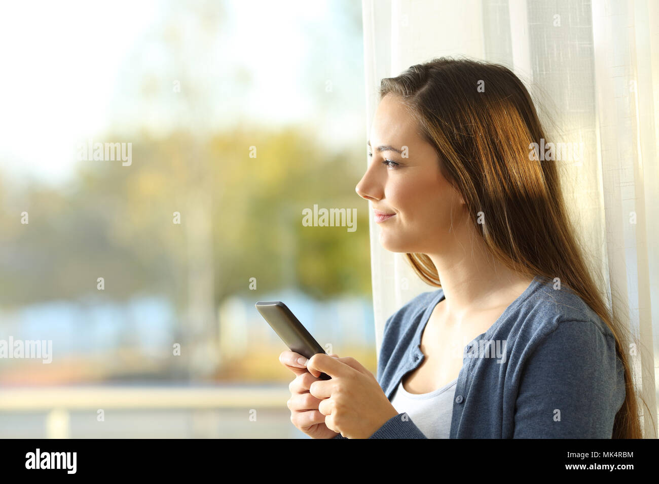 Side view portrait of a distracted woman using a smart phone looking ...