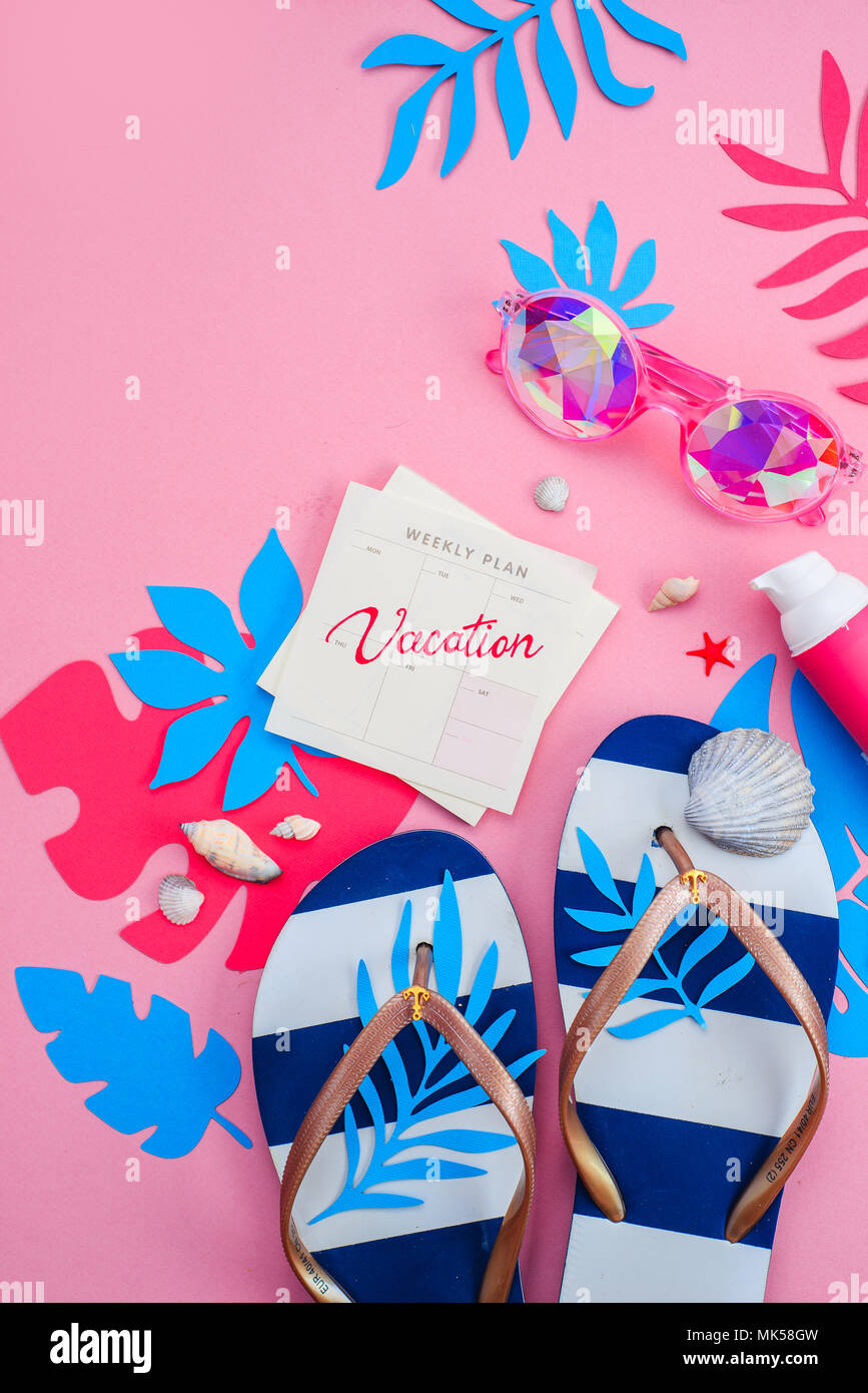 Flip flops, sunglasses and sunscreen on a vibrant pink background with ...