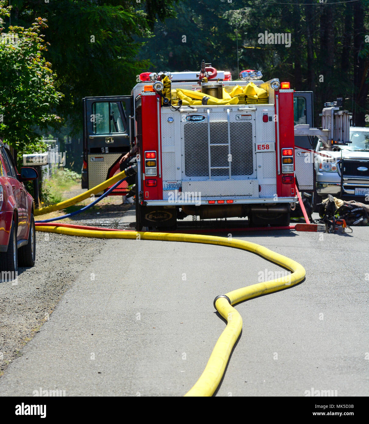 Fire Hose behind a fire truck during a fire Stock Photo - Alamy