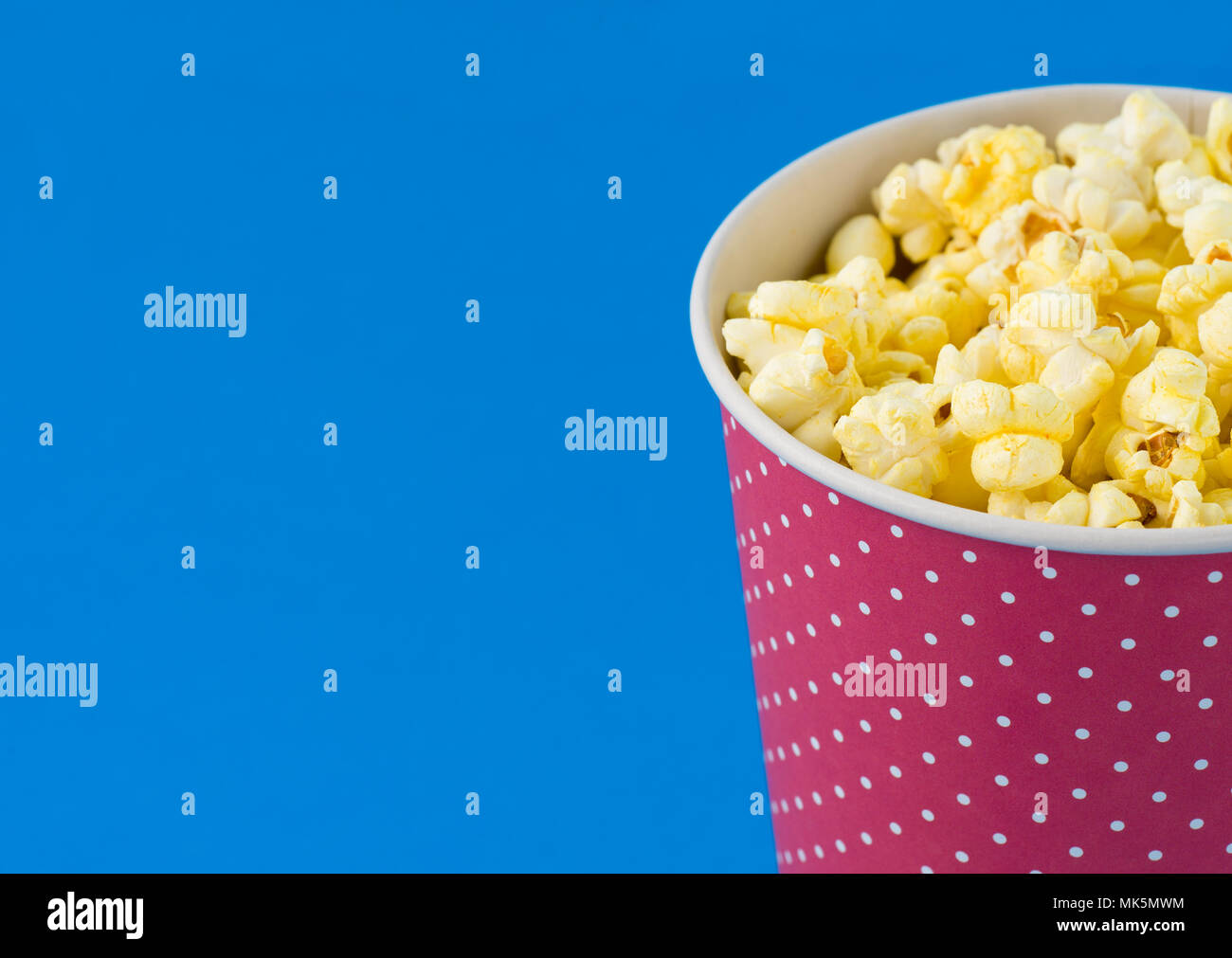Popcorn in a pack on a blue background Stock Photo - Alamy