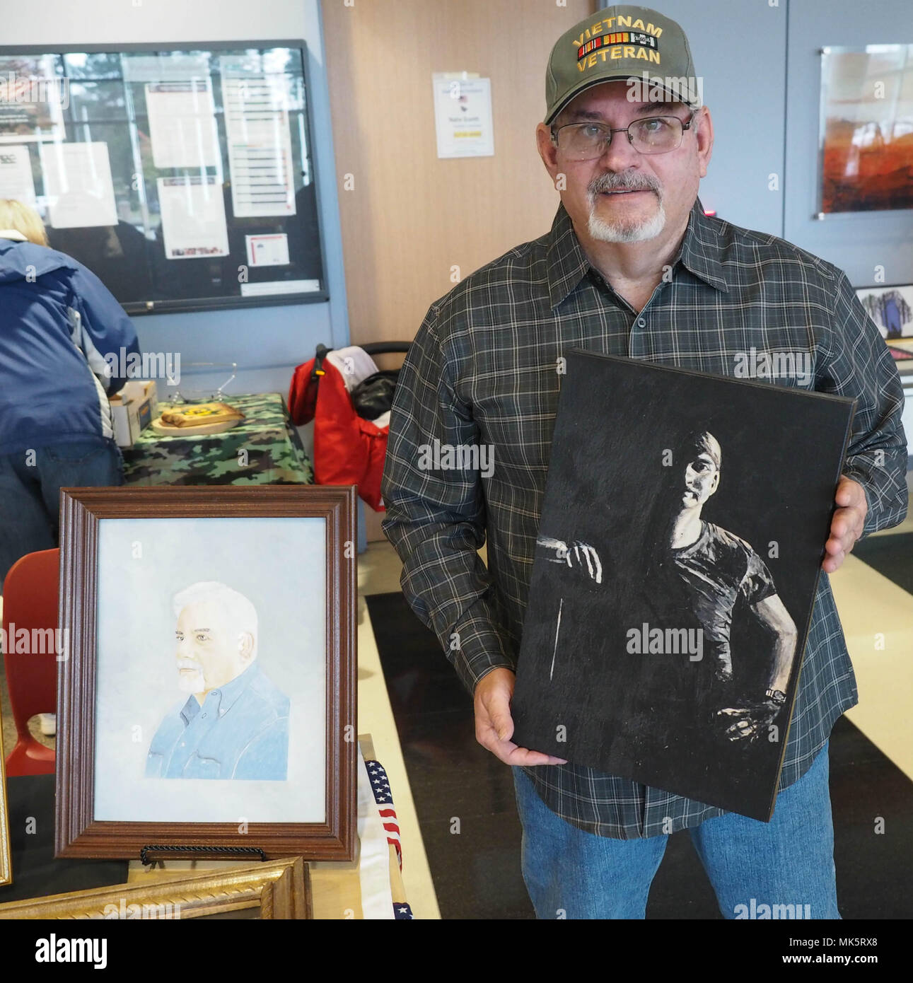 Army Veteran John Sitman shows off a painting of his late Army Veteran ...