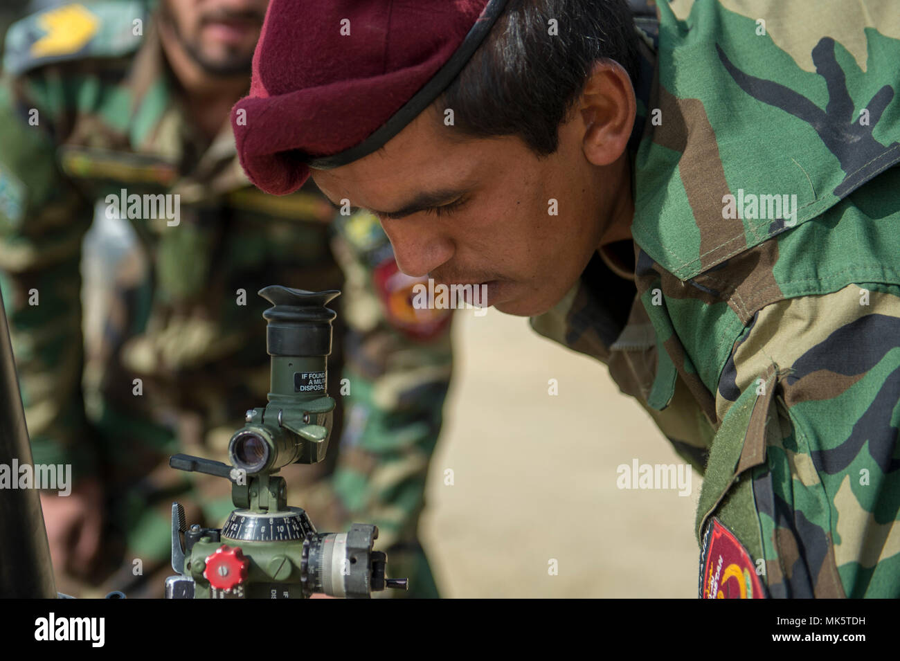 An Afghan Commando adjusts the sight to a 60mm mortar launcher during ...