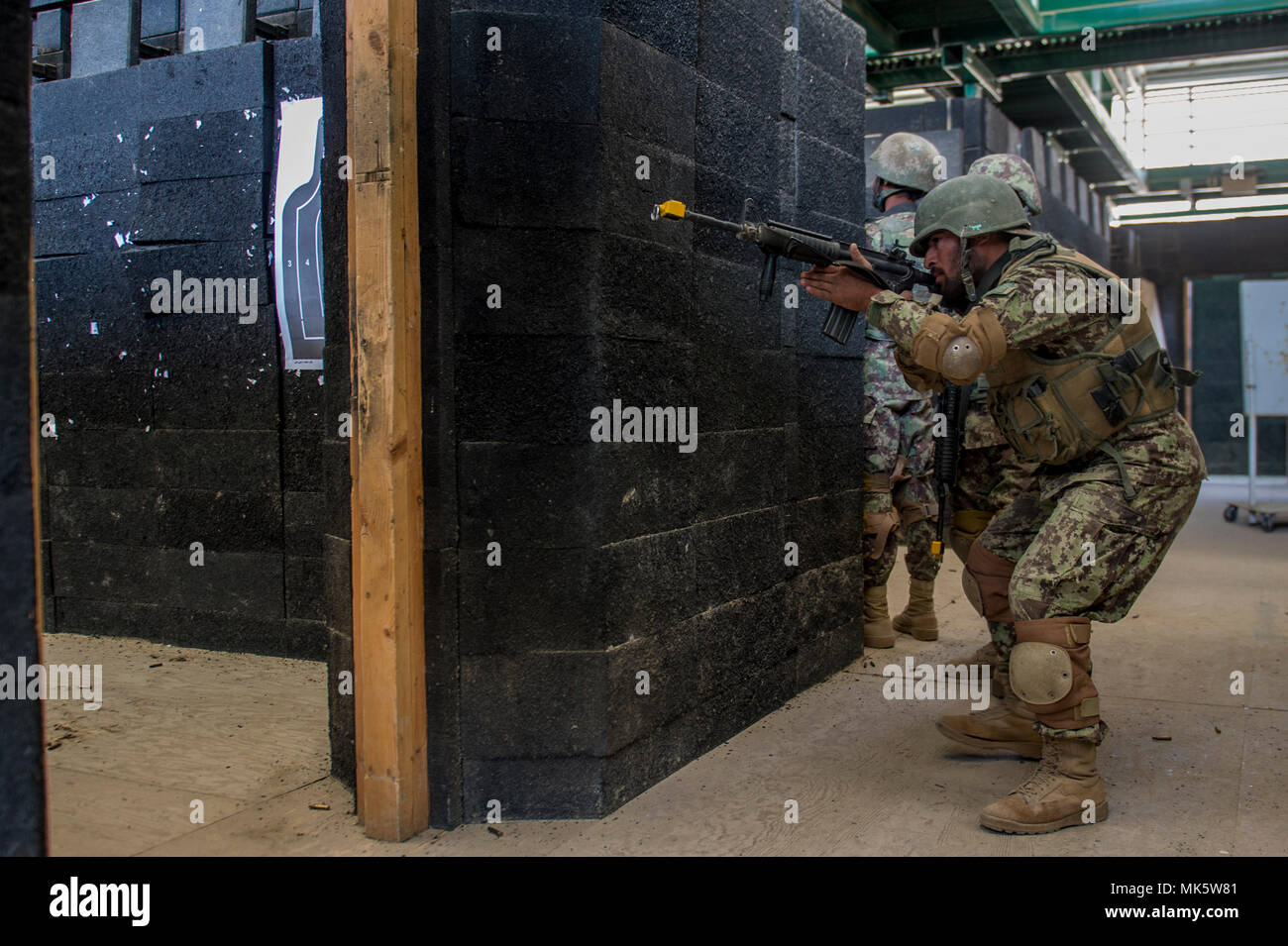 An Afghan Commando trainee and his team prepare to enter a room during ...
