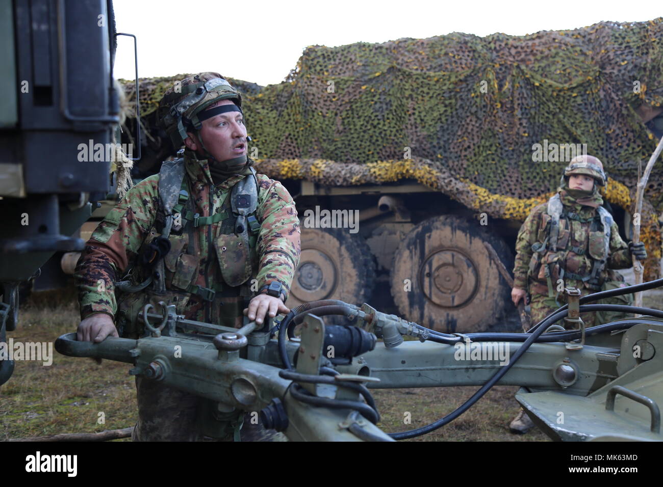 Italian soldier of the 24th Field Artillery Battalion attaches an M777 ...