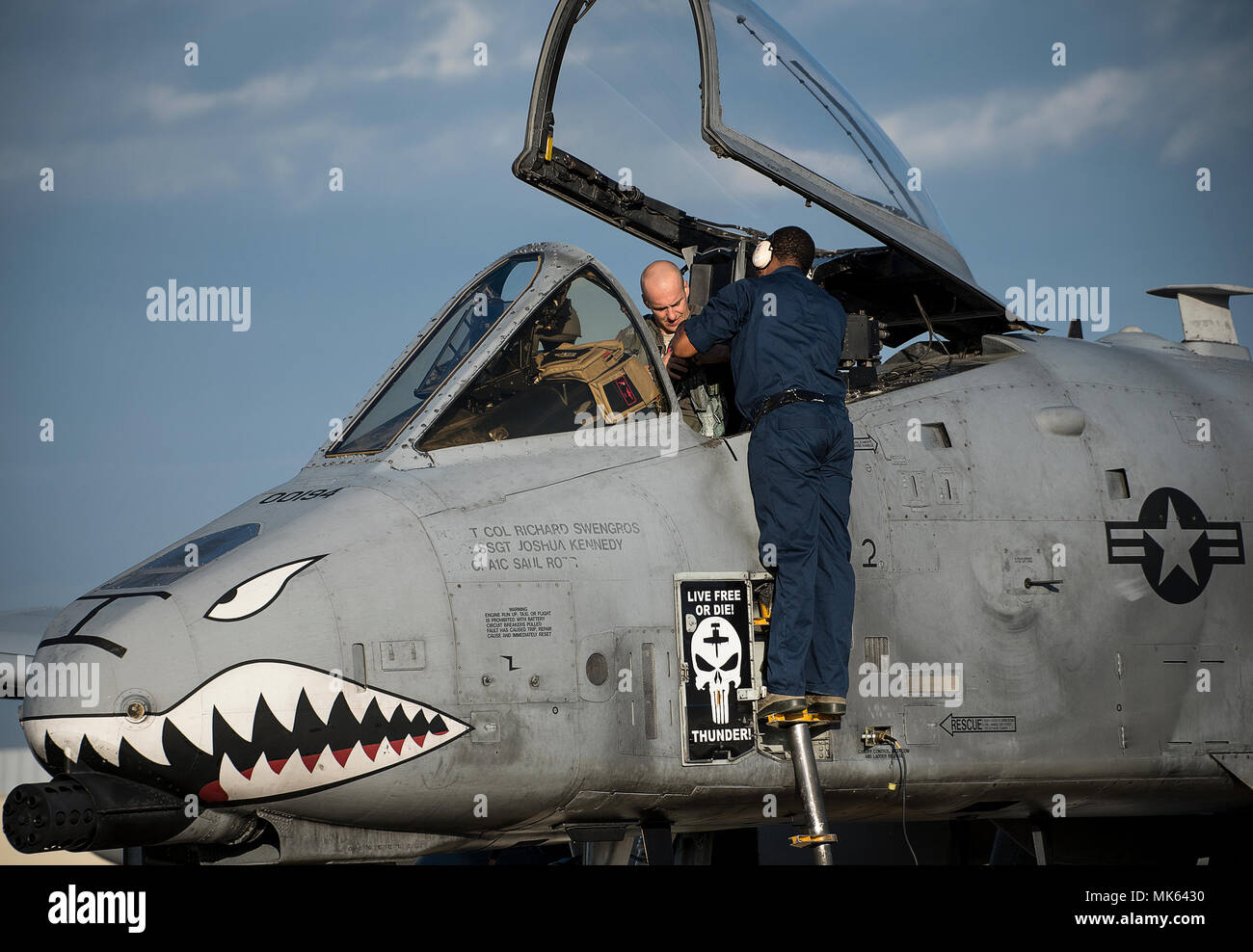 A crew chief helps a pilot strap into an A-10 Thunderbolt II Nov. 2 at ...