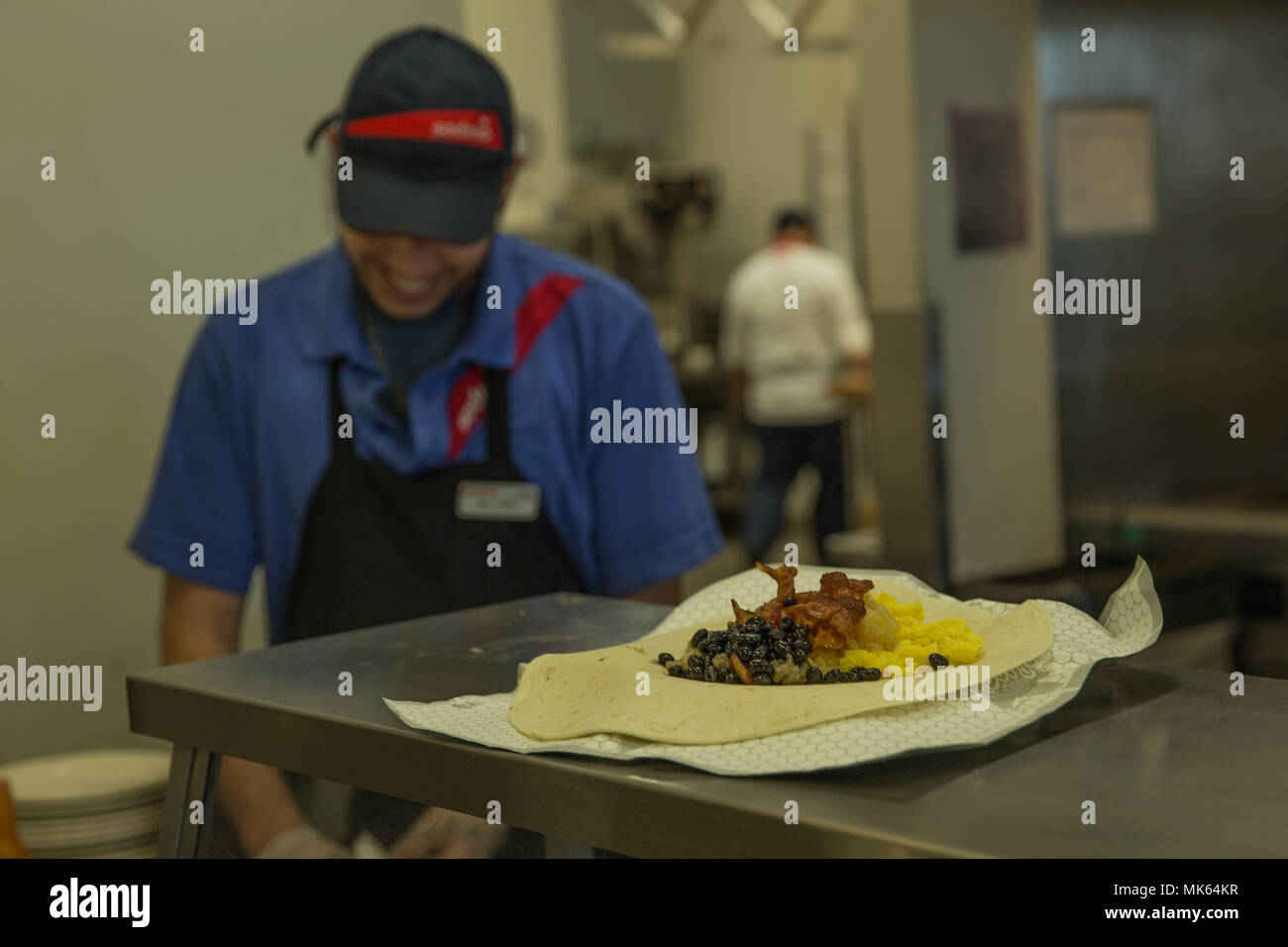 A mess hall employee prepares a breakfast burrito on Camp Pendleton ...