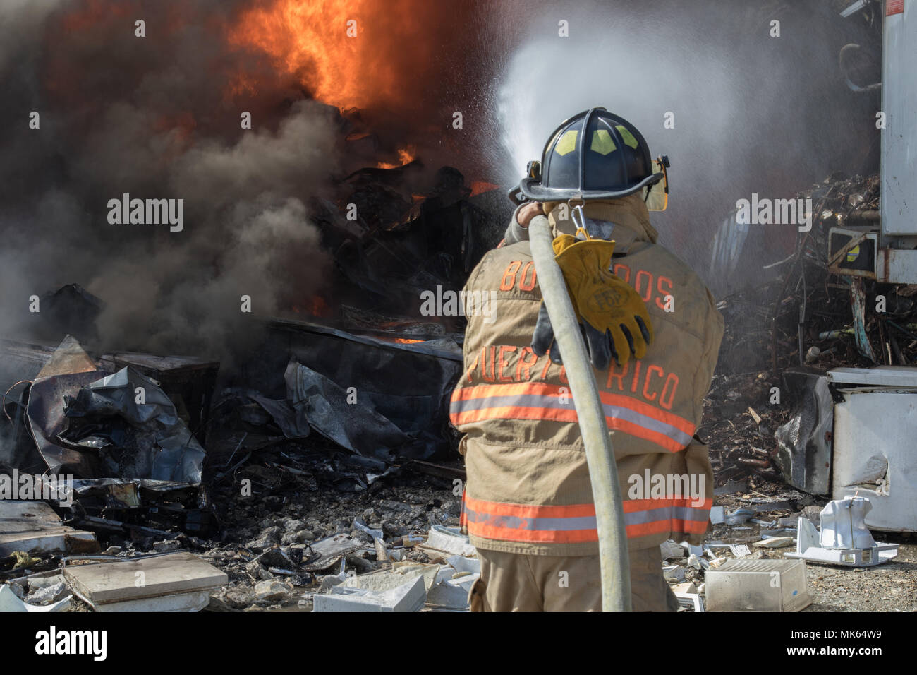 SAN JUAN, Puerto Rico – A Puerto Rican firefighter steadies a hose on ...