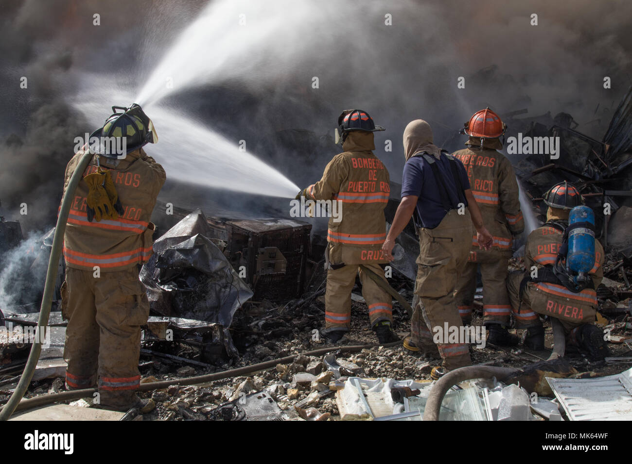 SAN JUAN, Puerto Rico – Firefighters work to smother flames at Homeca ...