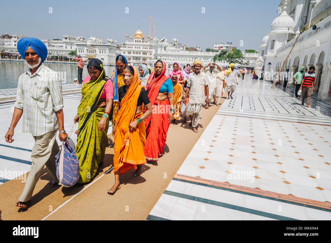 Amritsar, Punjab, India : A row of Sikh pilgrims walks around the Amrit ...