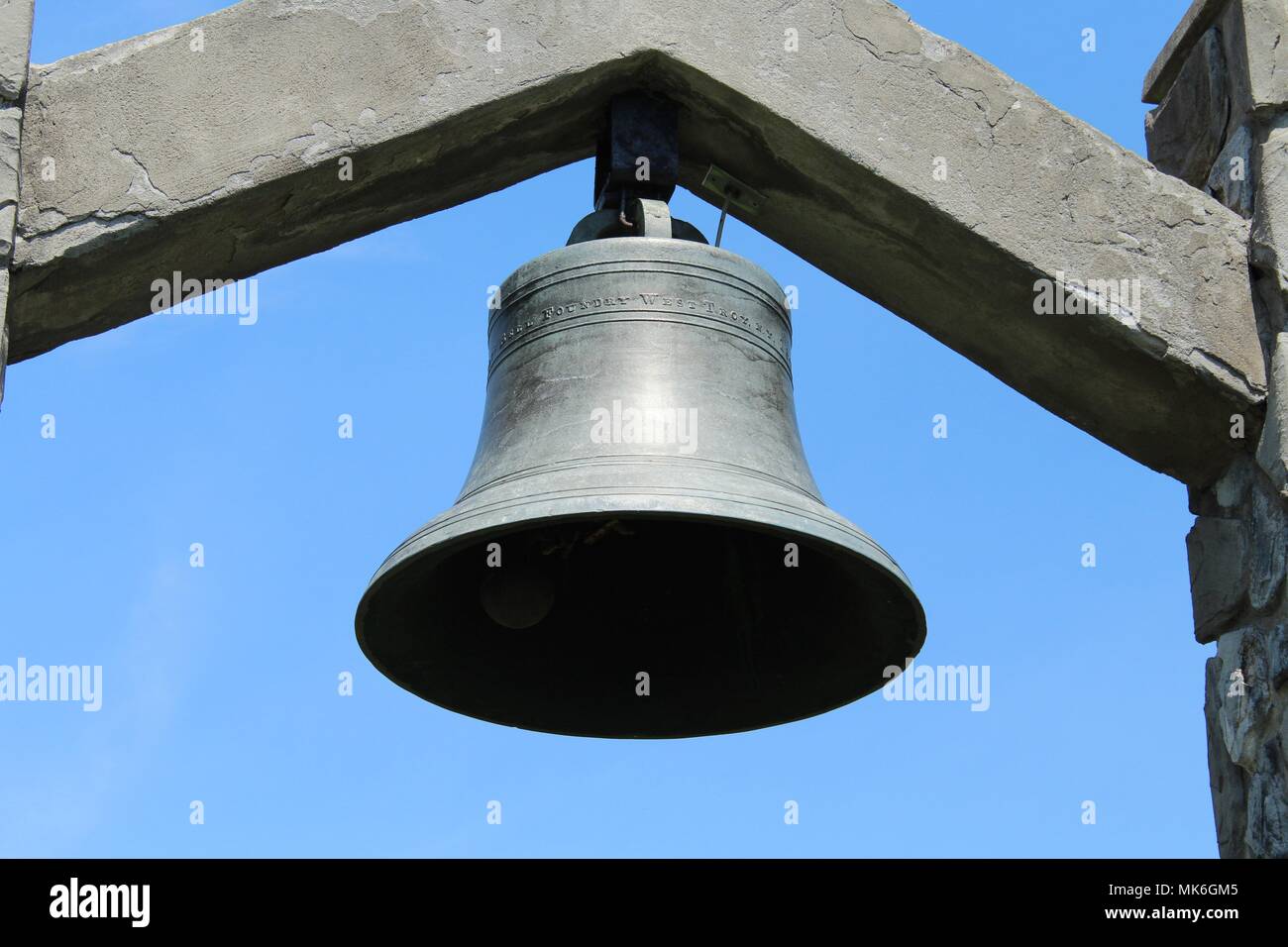 a close view of a church bell, with a portion of the supporting ...