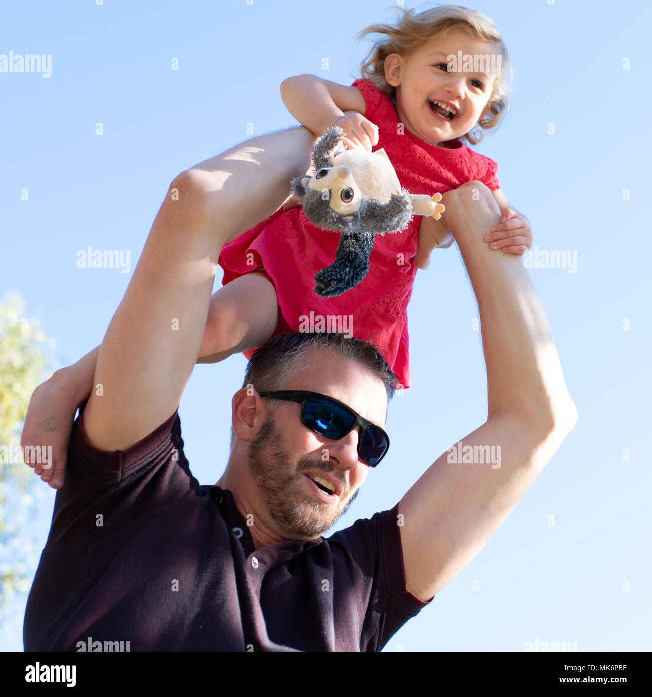 A father lifts his daughter above his head during a family photoshoot ...