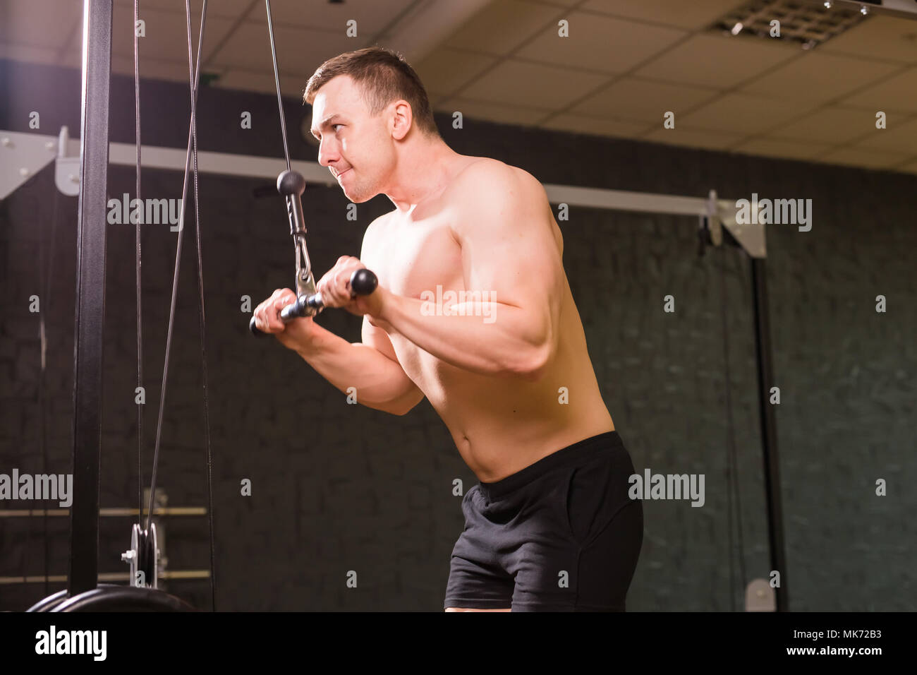 Strong muscular bodybuilder doing exercise in the gym. Fitness training ...