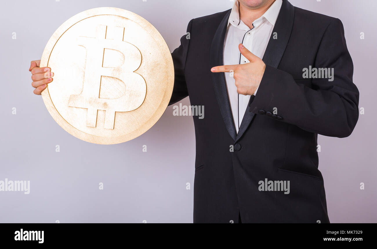 Close up of man holding big bitcoin on white background Stock Photo - Alamy
