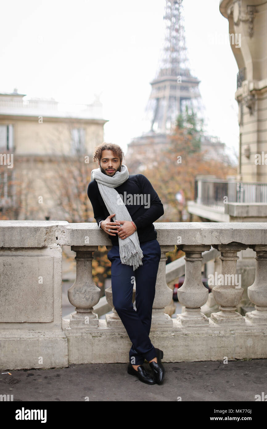 Afro american handsome young man standing near concrete railing with ...