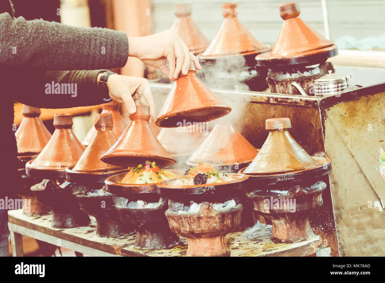 Cooking traditional Moroccan dish, meat and vegetable in ceramic tajine ...