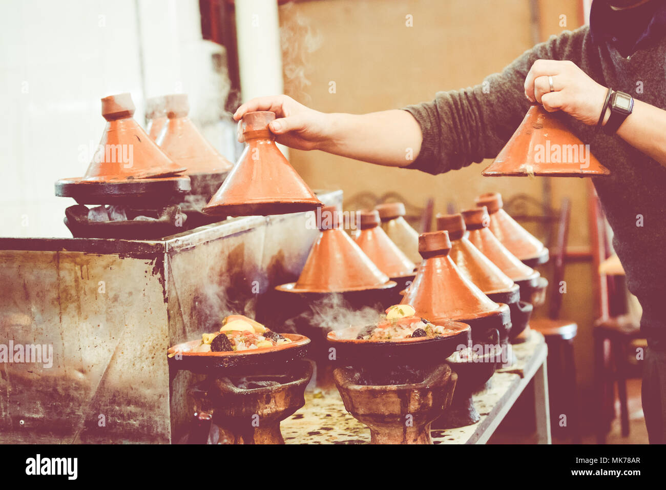 Cooking traditional Moroccan dish, meat and vegetable in ceramic tajine ...