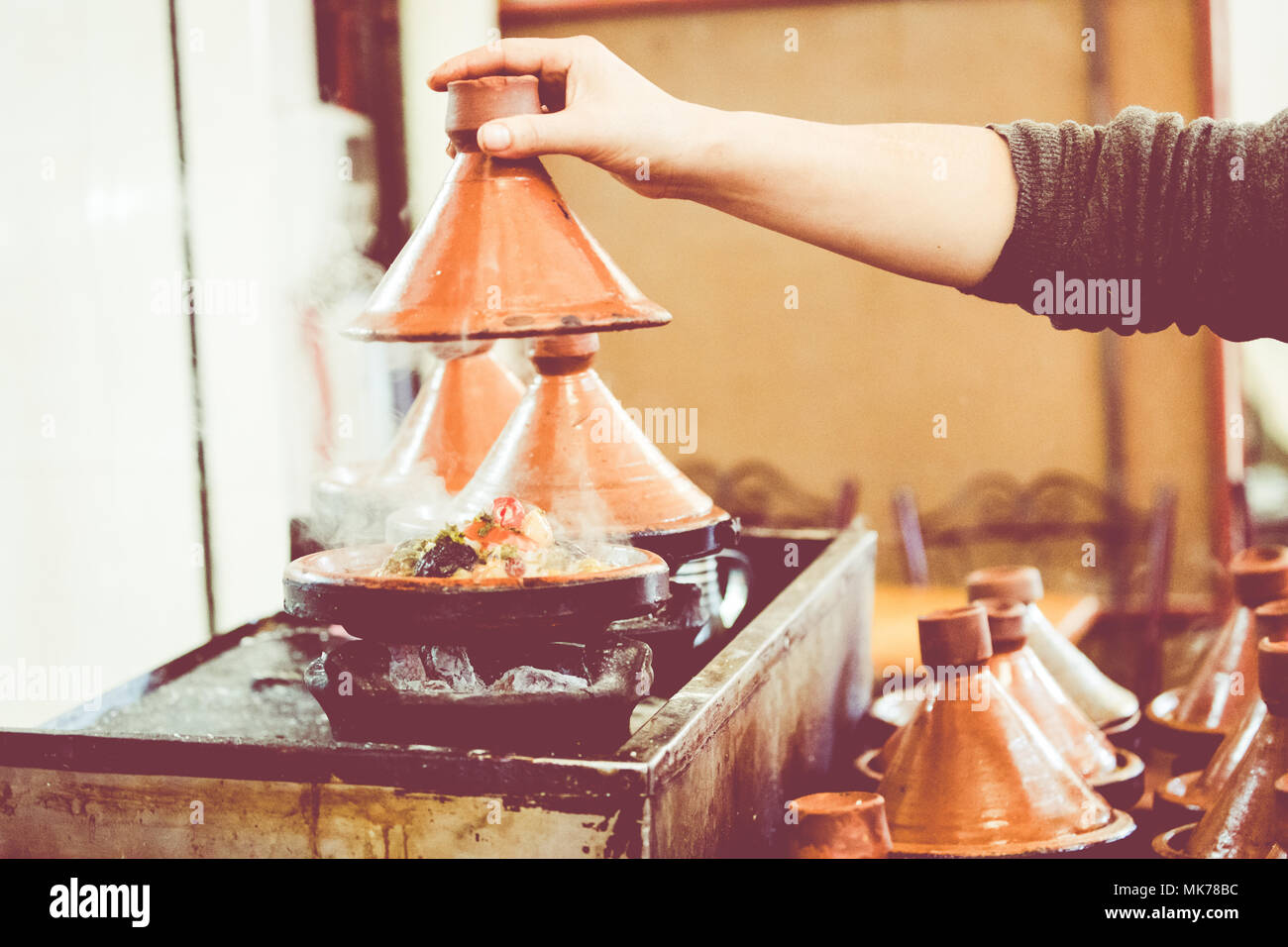 Cooking traditional Moroccan dish, meat and vegetable in ceramic tajine ...