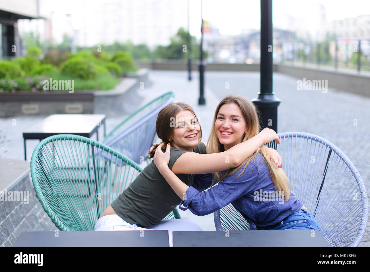 Smiling women sitting at cafe outside Stock Photo - Alamy
