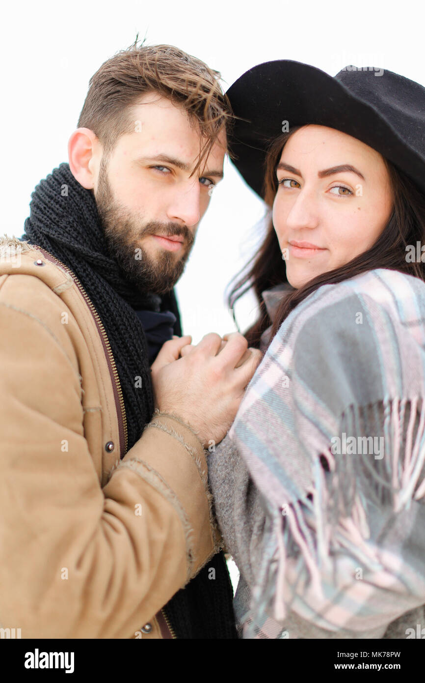 Portrait of caucasian couple wearing scarf and hat in white background ...