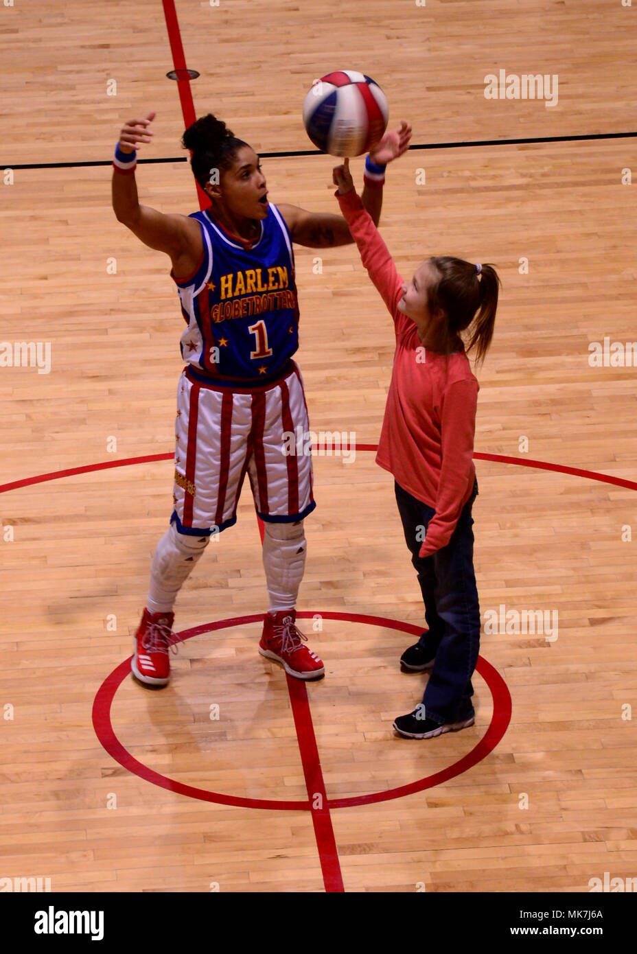 Ace Jackson, member of the Harlem Globetrotters, spins a basketball on ...