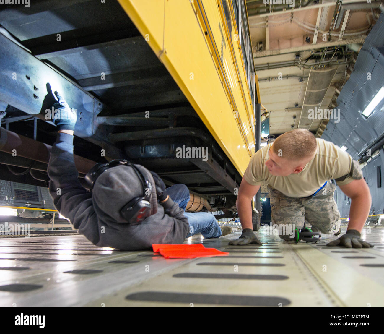 U.S. Airmen from the 60th Aerial Port Squadron load buses onto a C-5M ...